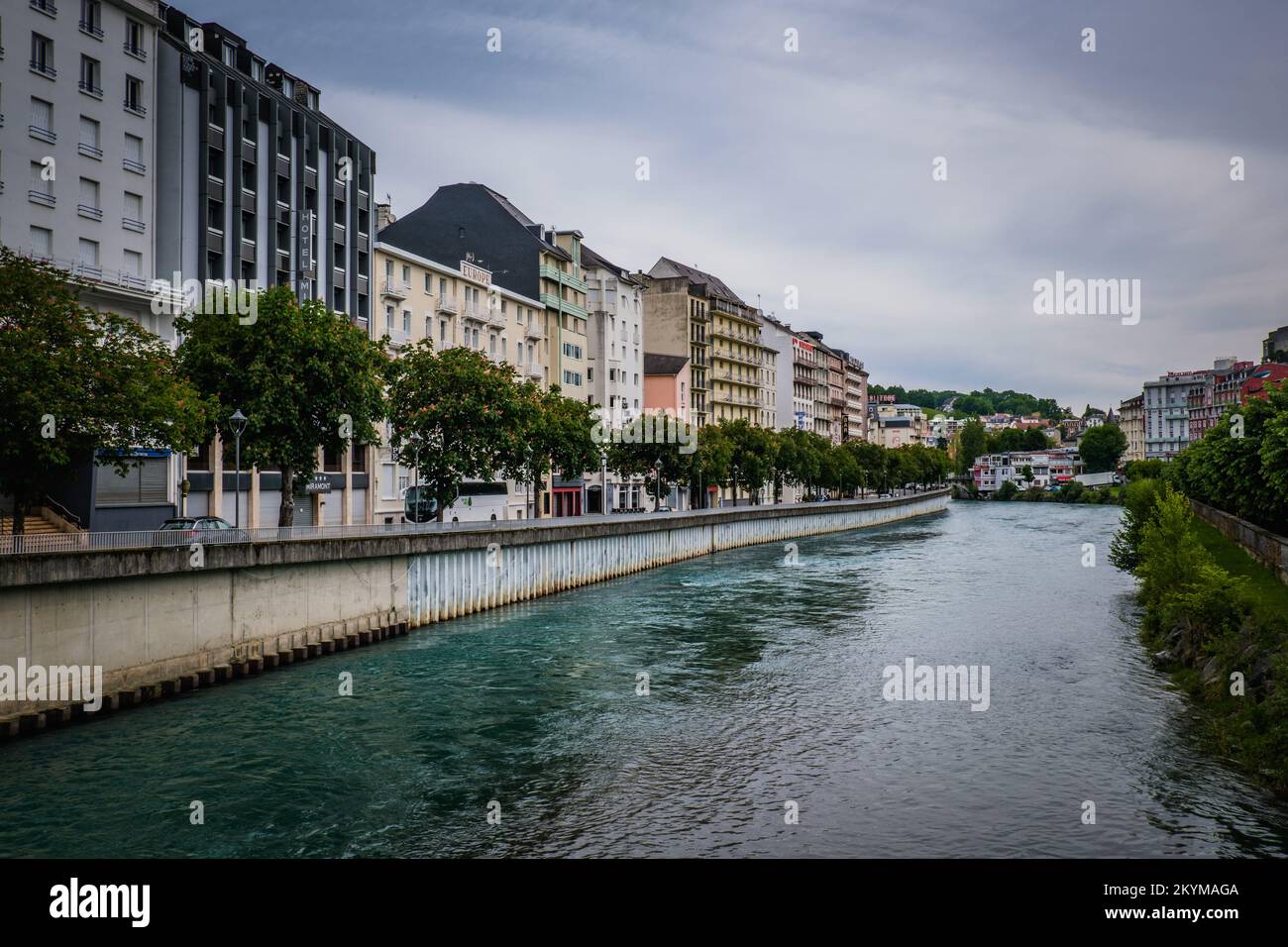 Riverbanks of the Gave de Pau river in the pilgrimage city of Lourdes ...