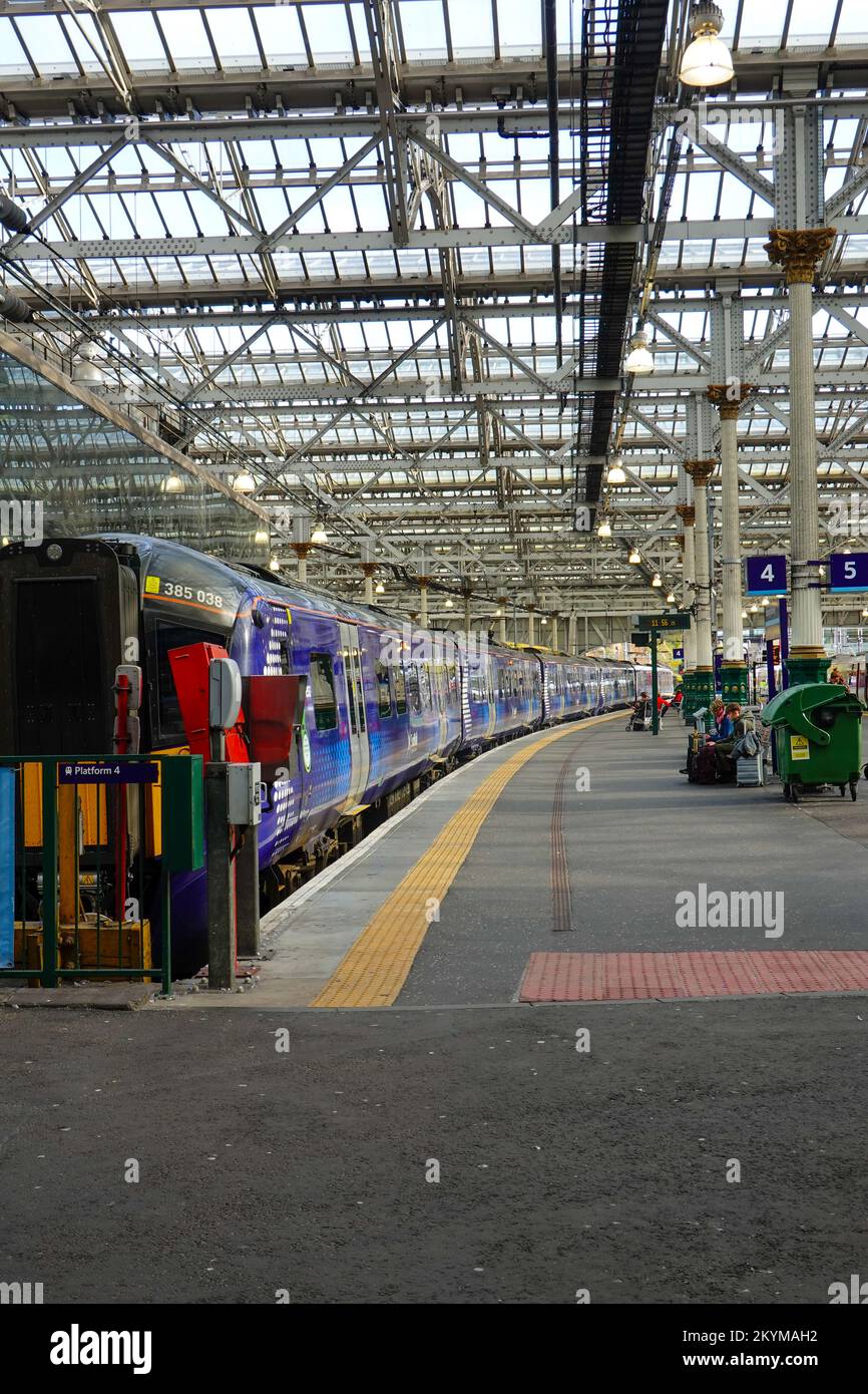 ScotRail train at Waverley Edinburgh Platform 4, while people sit and ...