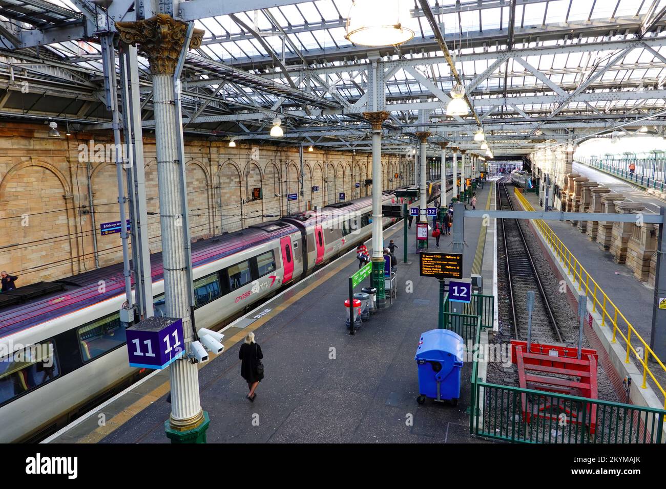 CrossCountry train, with people walking down the adjoining platform ...