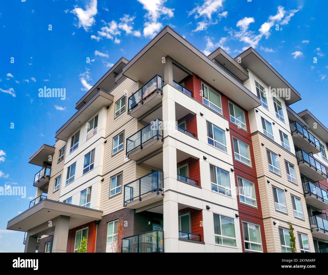 New low-rise residential building on blue and cloudy sky background ...