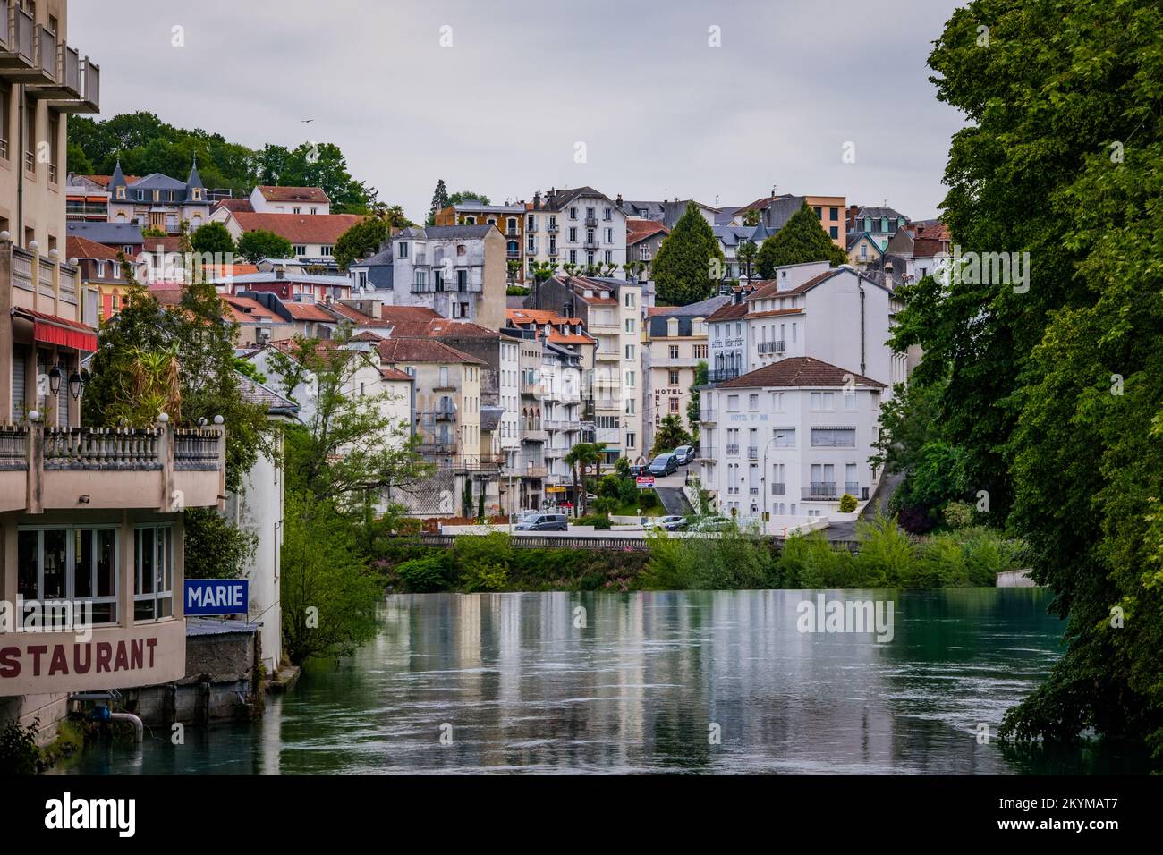 Riverbanks of the Gave de Pau river in the pilgrimage city of Lourdes ...
