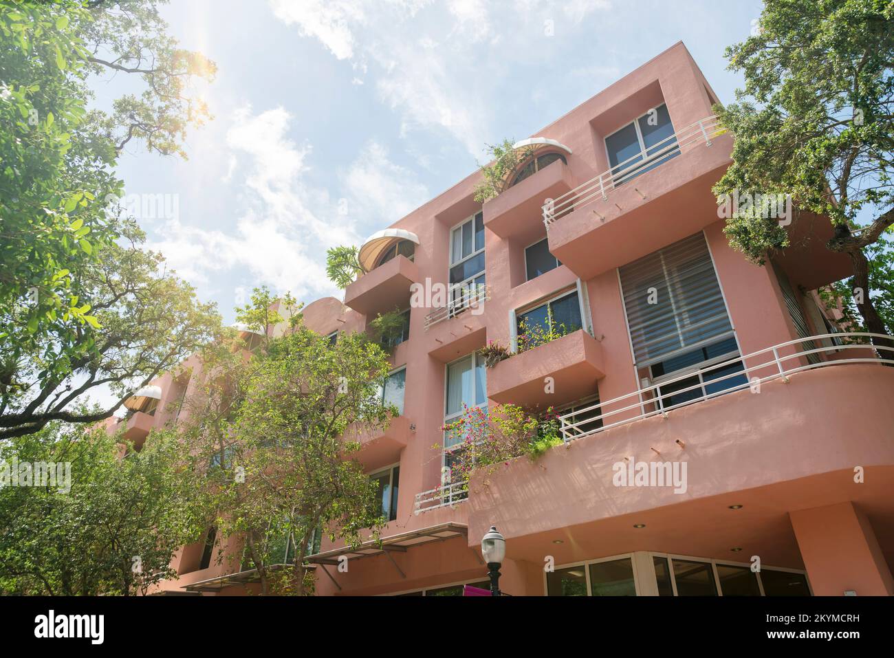 Building with painted peach wall and balconies facing the trees at the ...