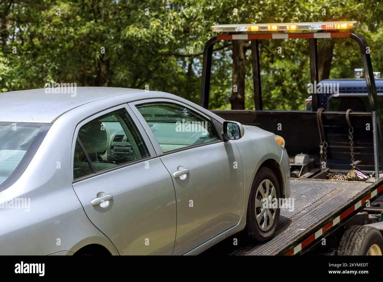 Working in towing service, loading damaged car that has been onto tow ...