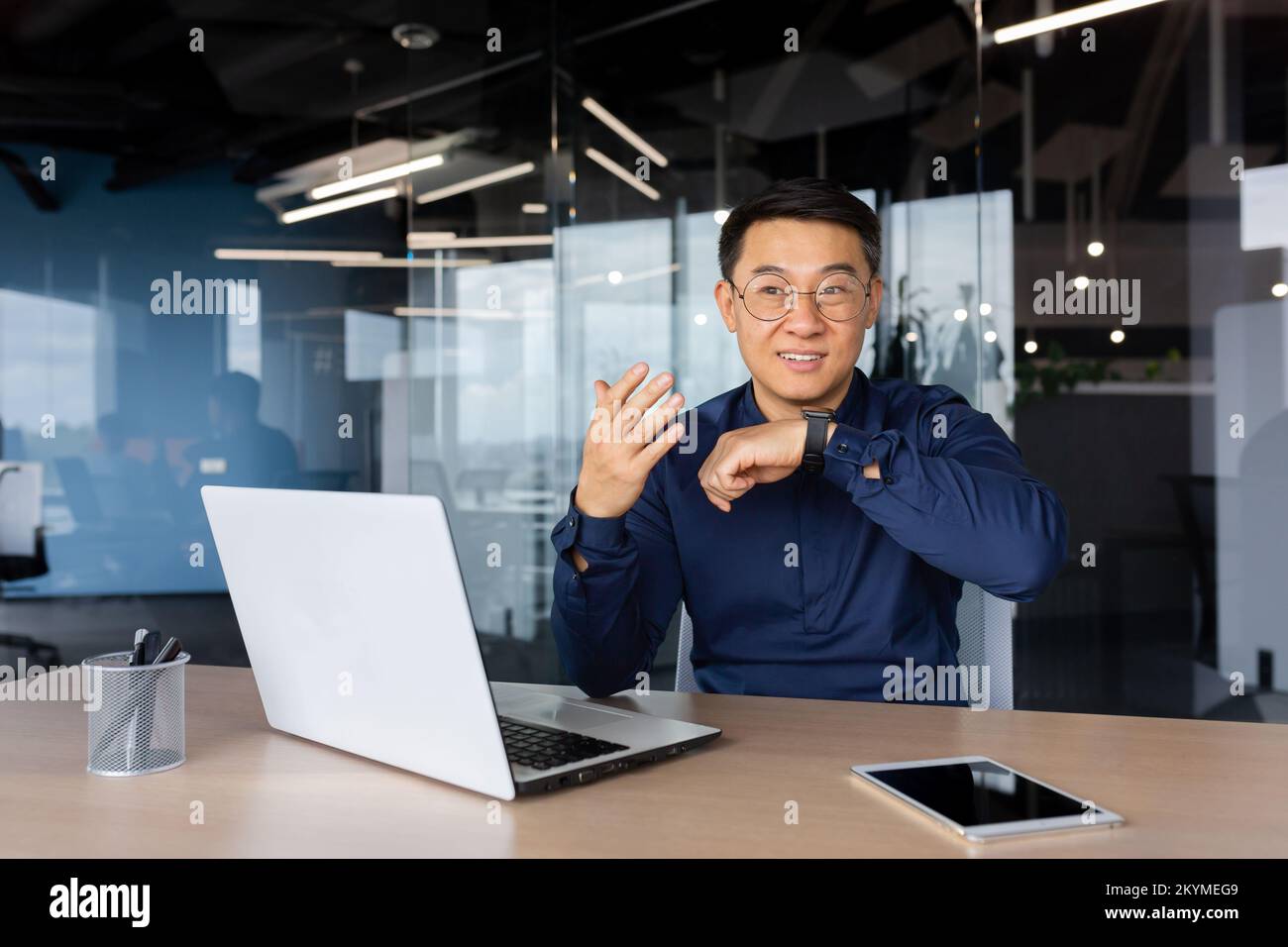 Asian businessman uses smartwatch to communicate, man gives commands to ...