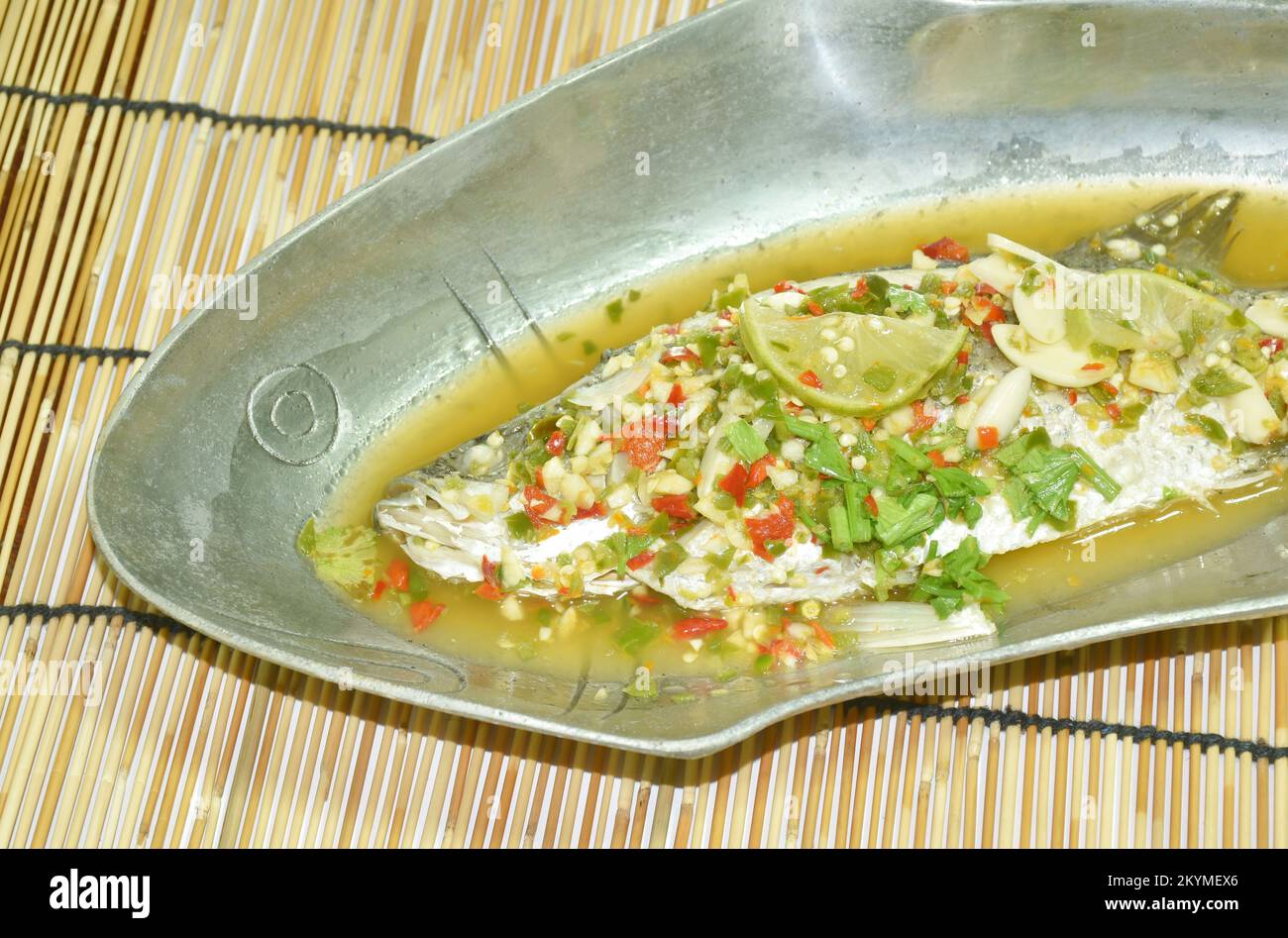steamed bass fish dressing lemon sweet and sour chili sauce on plate ...