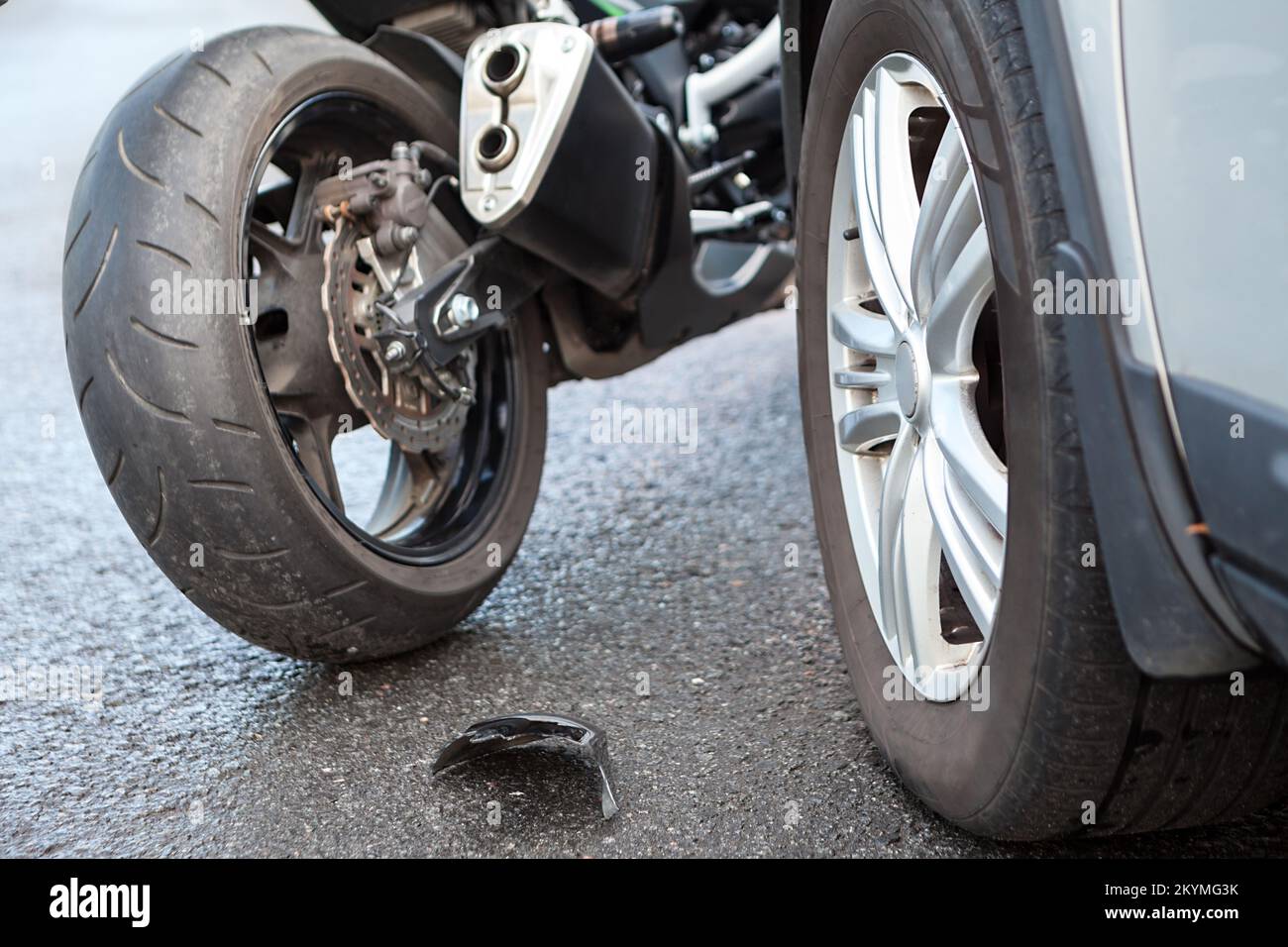 Motorcycle accident close-up view, broken parts laying on asphalt road ...