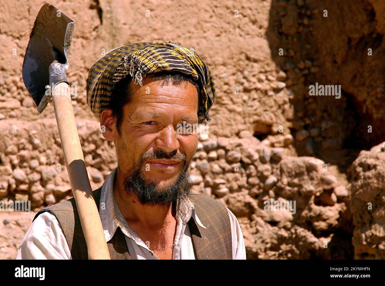 Bamyan (Bamiyan) / Central Afghanistan: A man carries a shovel as he ...