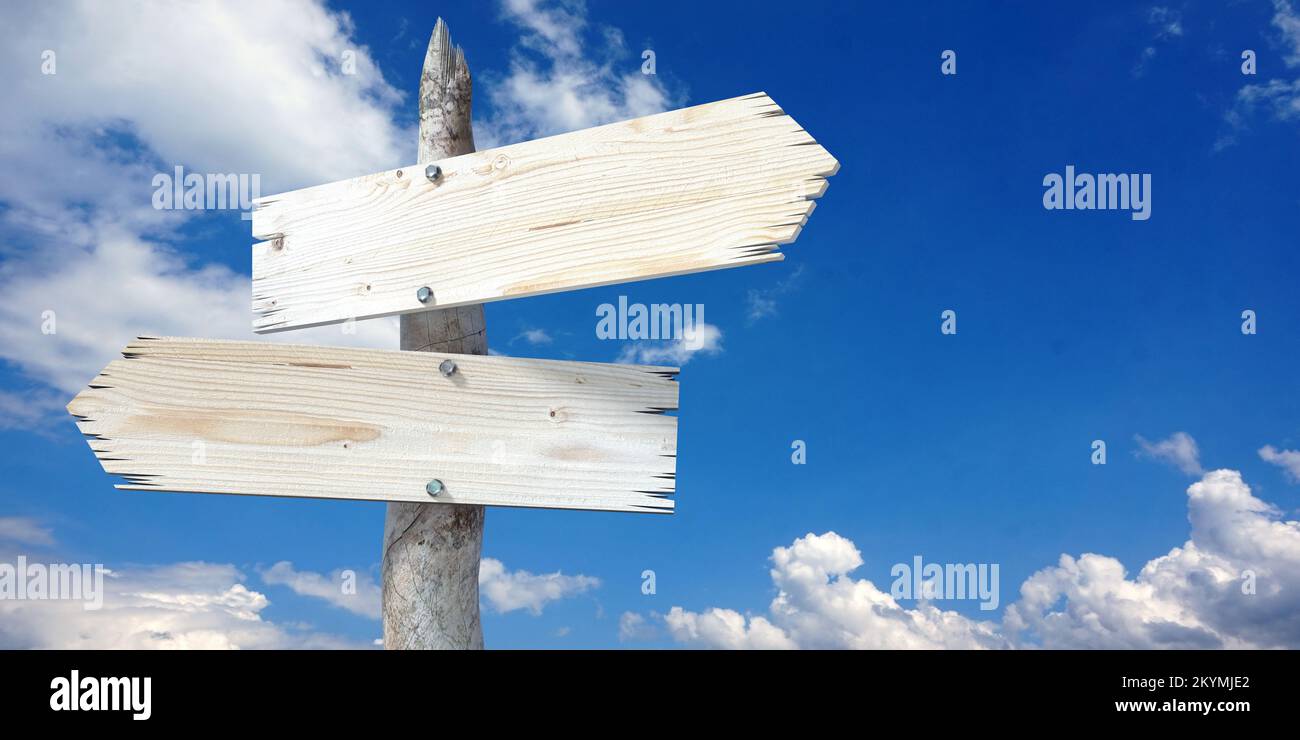 Wooden signpost with clear two arrows Stock Photo - Alamy