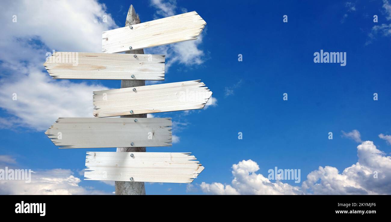 Wooden signpost with clear five arrows Stock Photo - Alamy