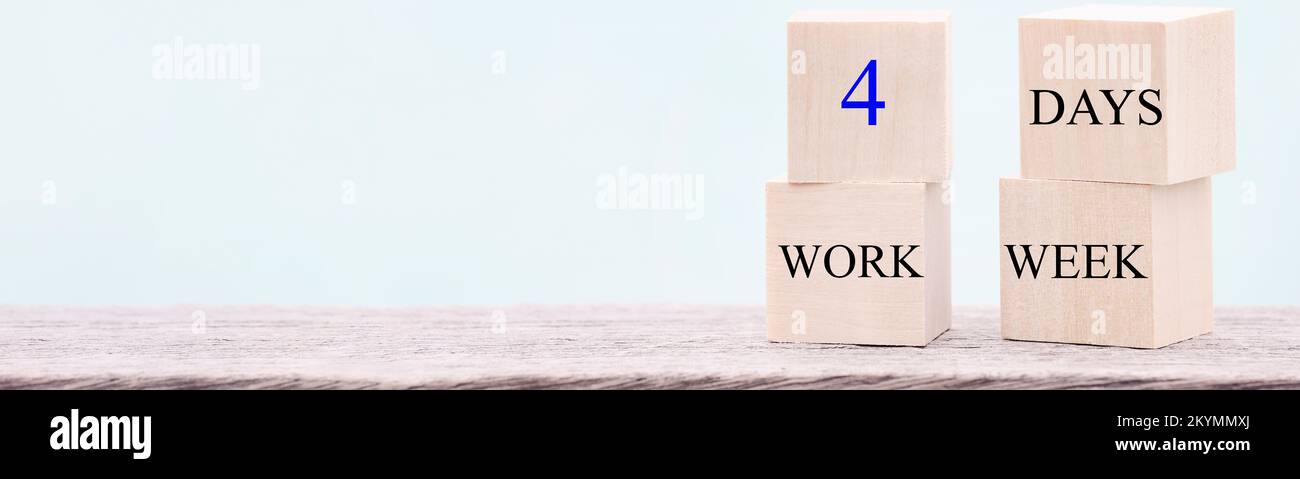 4 day working week words on wooden cube on blue background. reducing ...