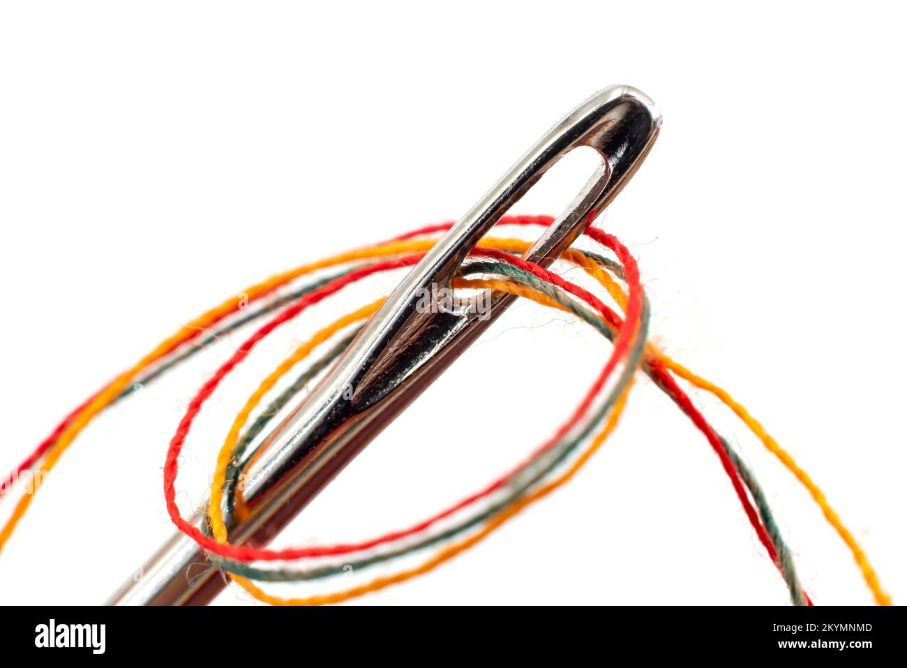 Needle with multi-colored threads on a white background. Eye of a ...
