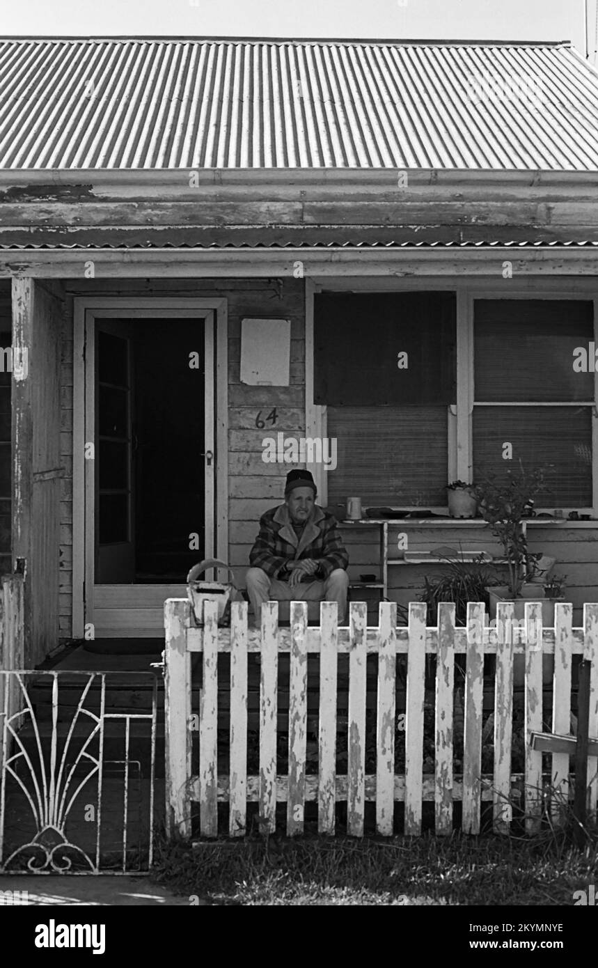 An old man sits outside his dilapidated shack: 64 Berner Street ...