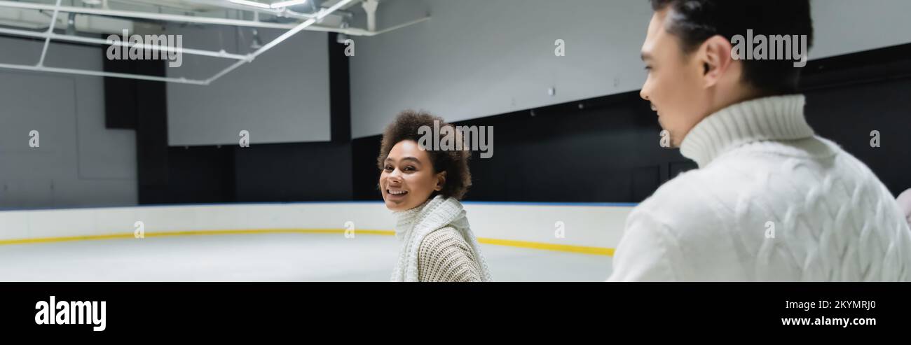 Young african american woman looking at camera near blurred boyfriend ...