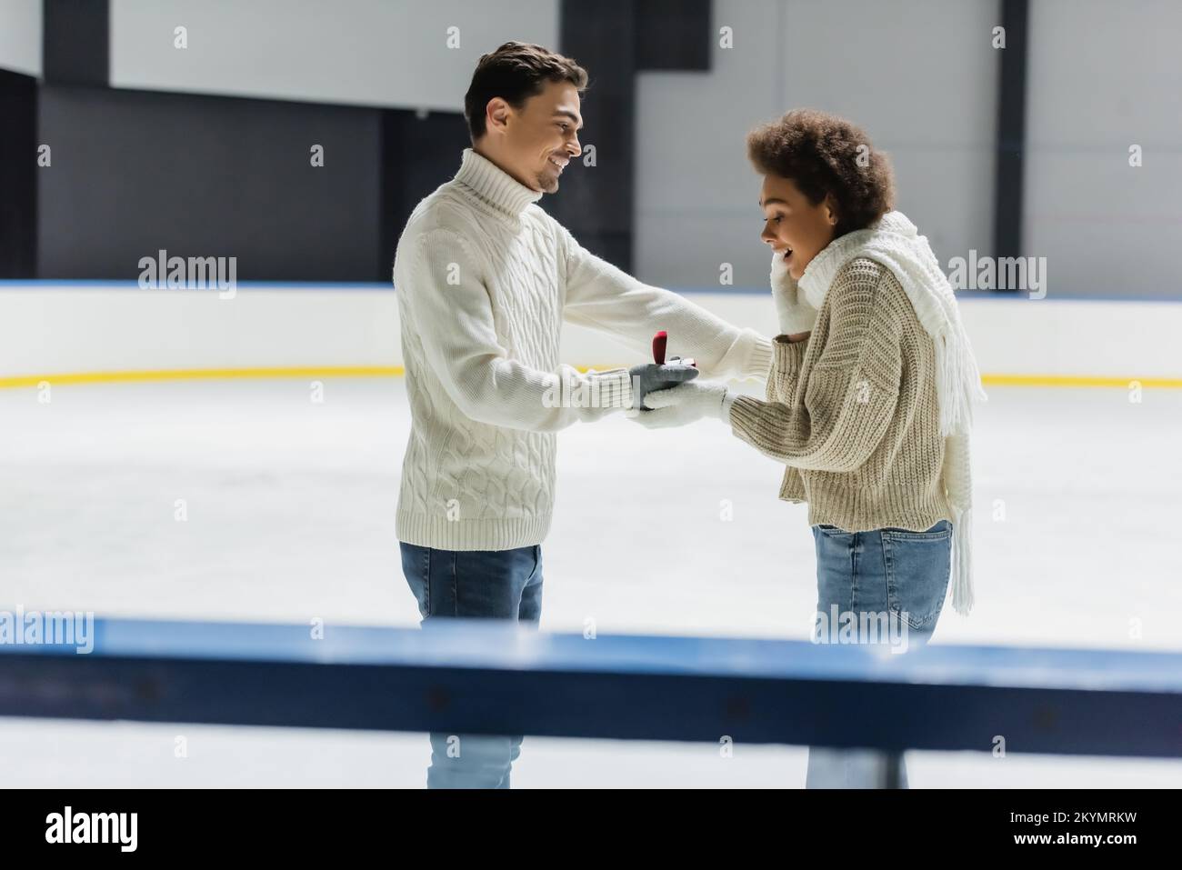 Side view of smiling man showing engagement ring at african american ...