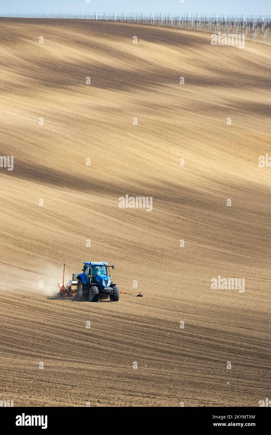 Tractor with seed drill in early spring landscape Stock Photo - Alamy