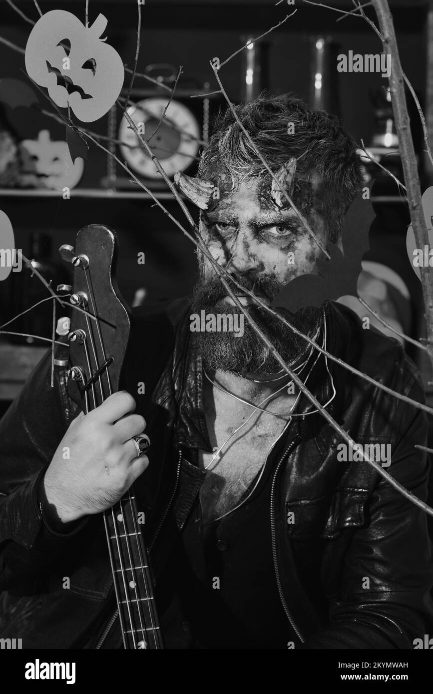 Demon with horns and evil face holds black electric guitar Stock Photo ...