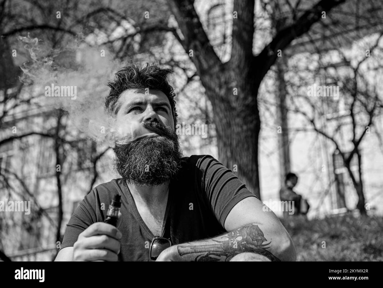 Vaping and habits concept. Man with beard and mustache smoking, urban ...