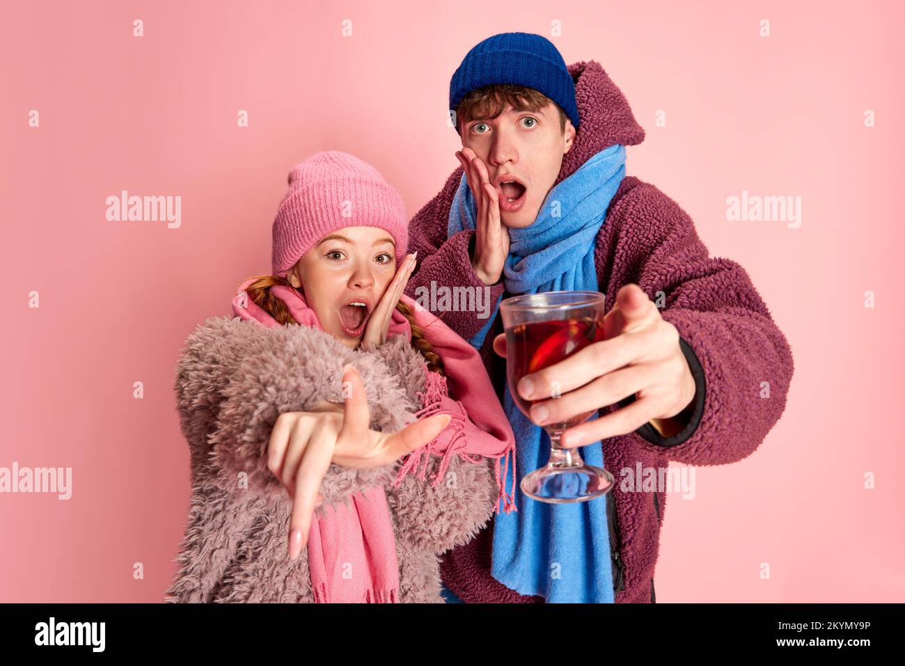 Portrait of young man and woman in knitted hat and scarf posing with ...