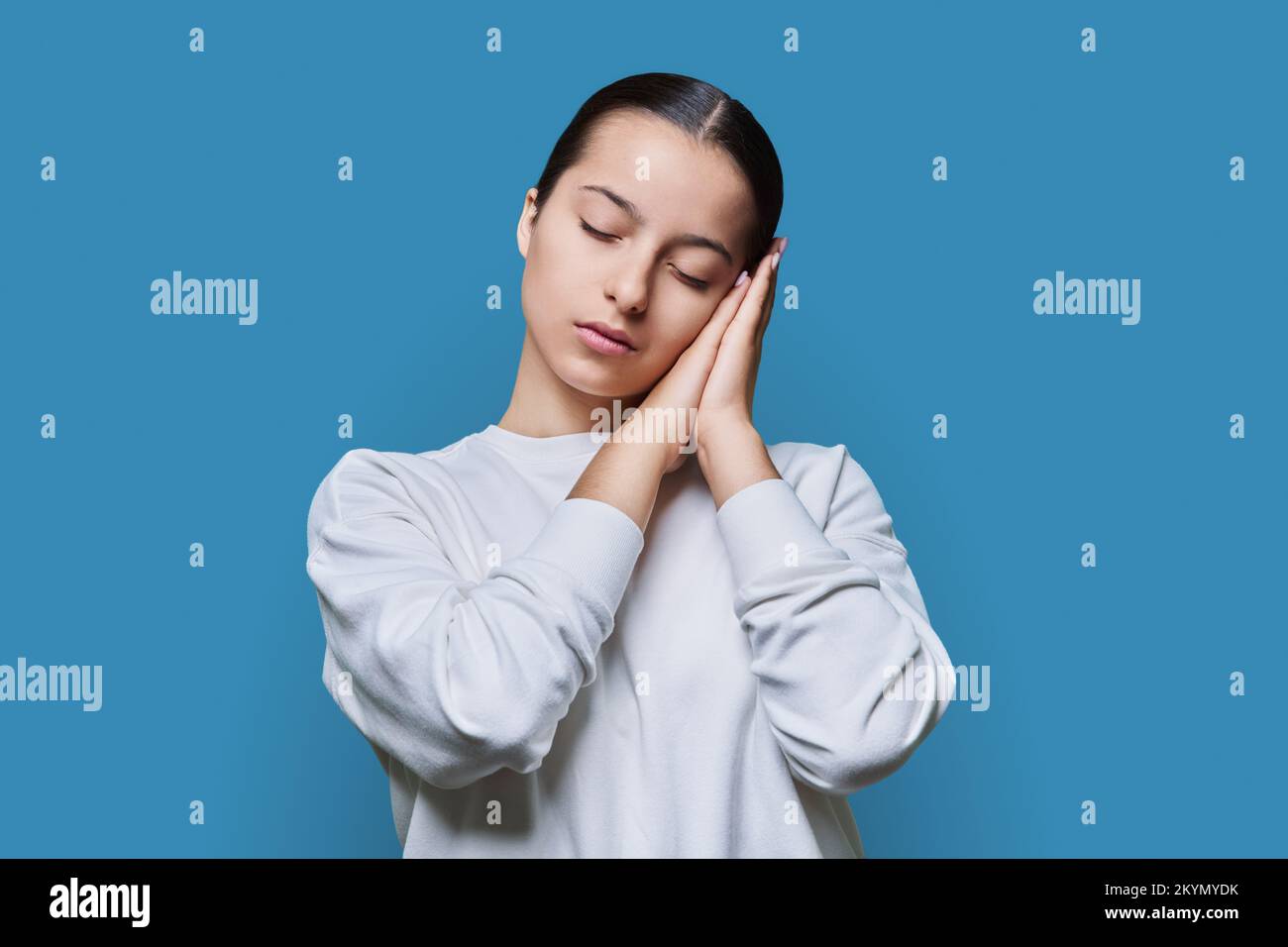Young woman sleeping with closed eyes, on blue studio background Stock ...