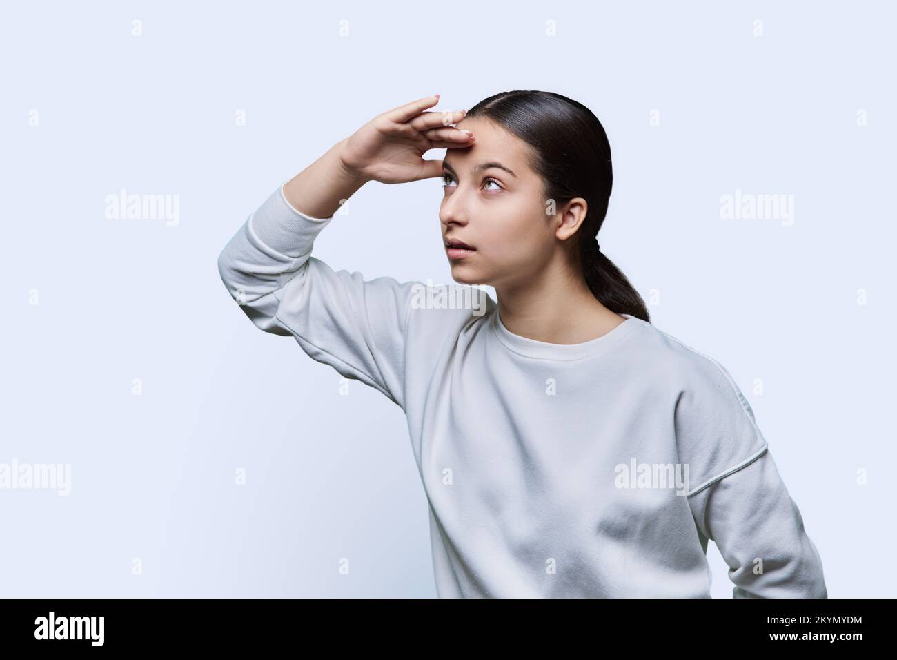 Teenage girl looking in distance with hand on her forehead Stock Photo ...