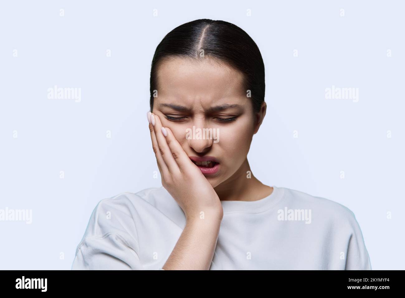 Teenage girl having toothache, on white studio background Stock Photo ...