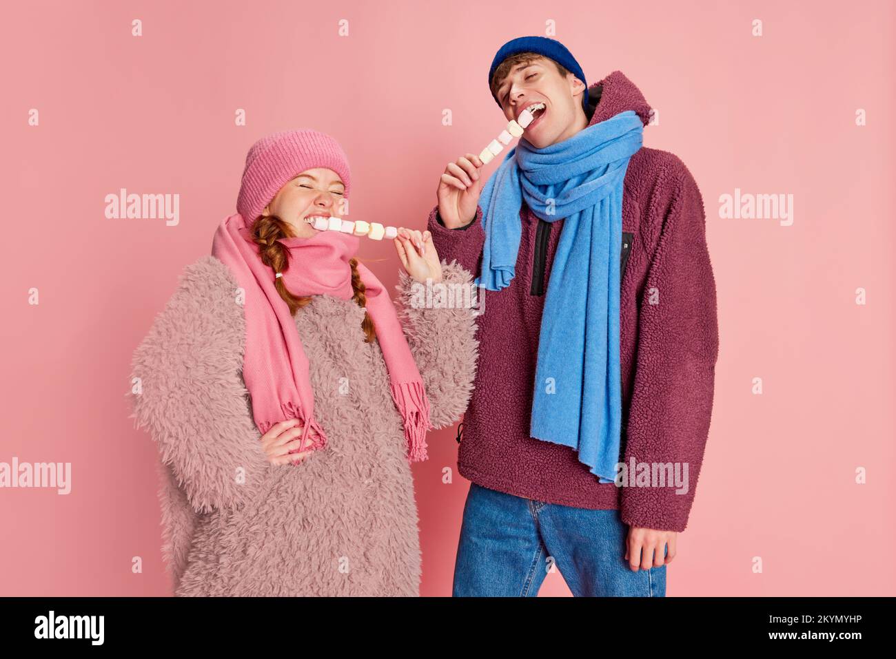 Portrait of young man and woman in knitted hat and scarf posing ...