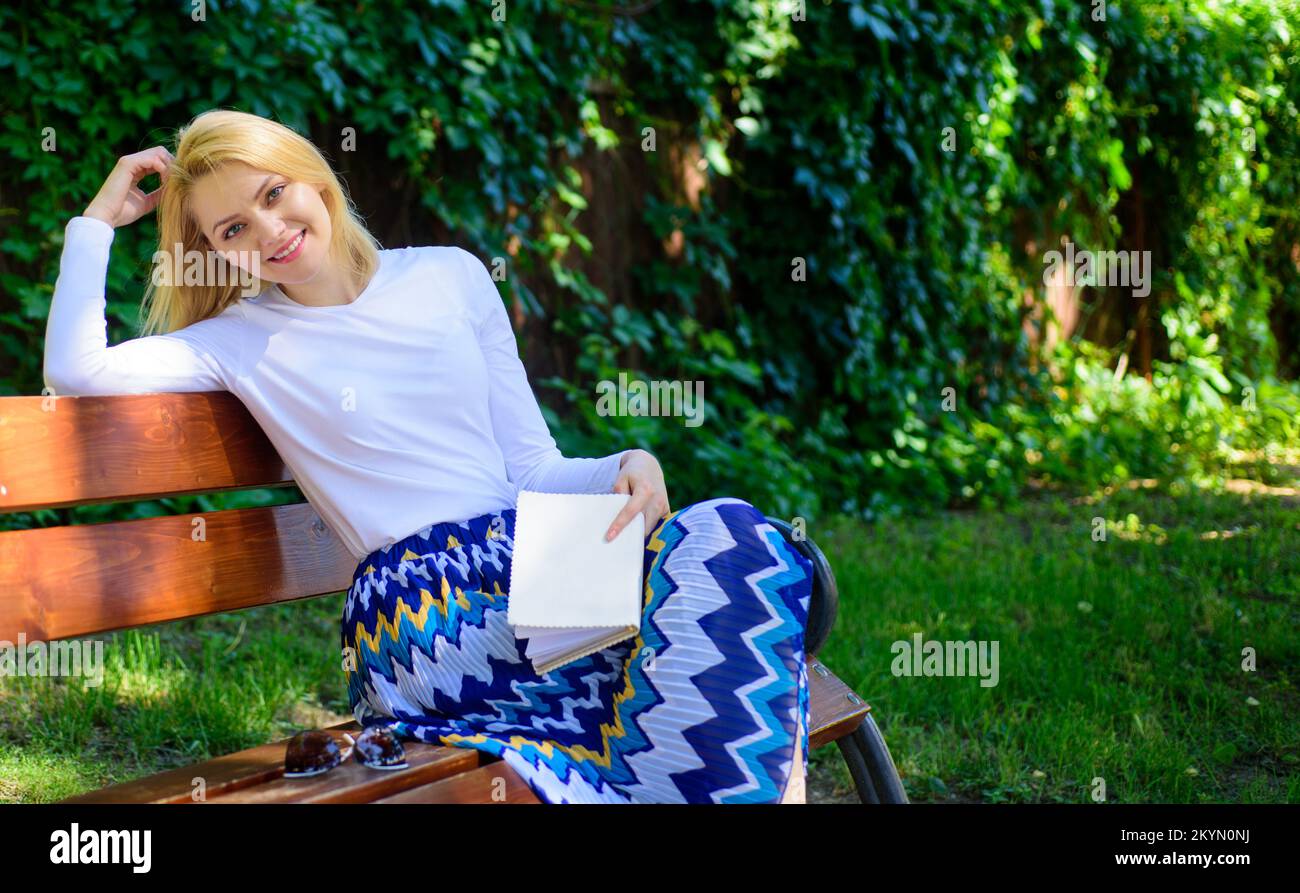 Woman happy smiling blonde take break relaxing in garden reading poetry ...