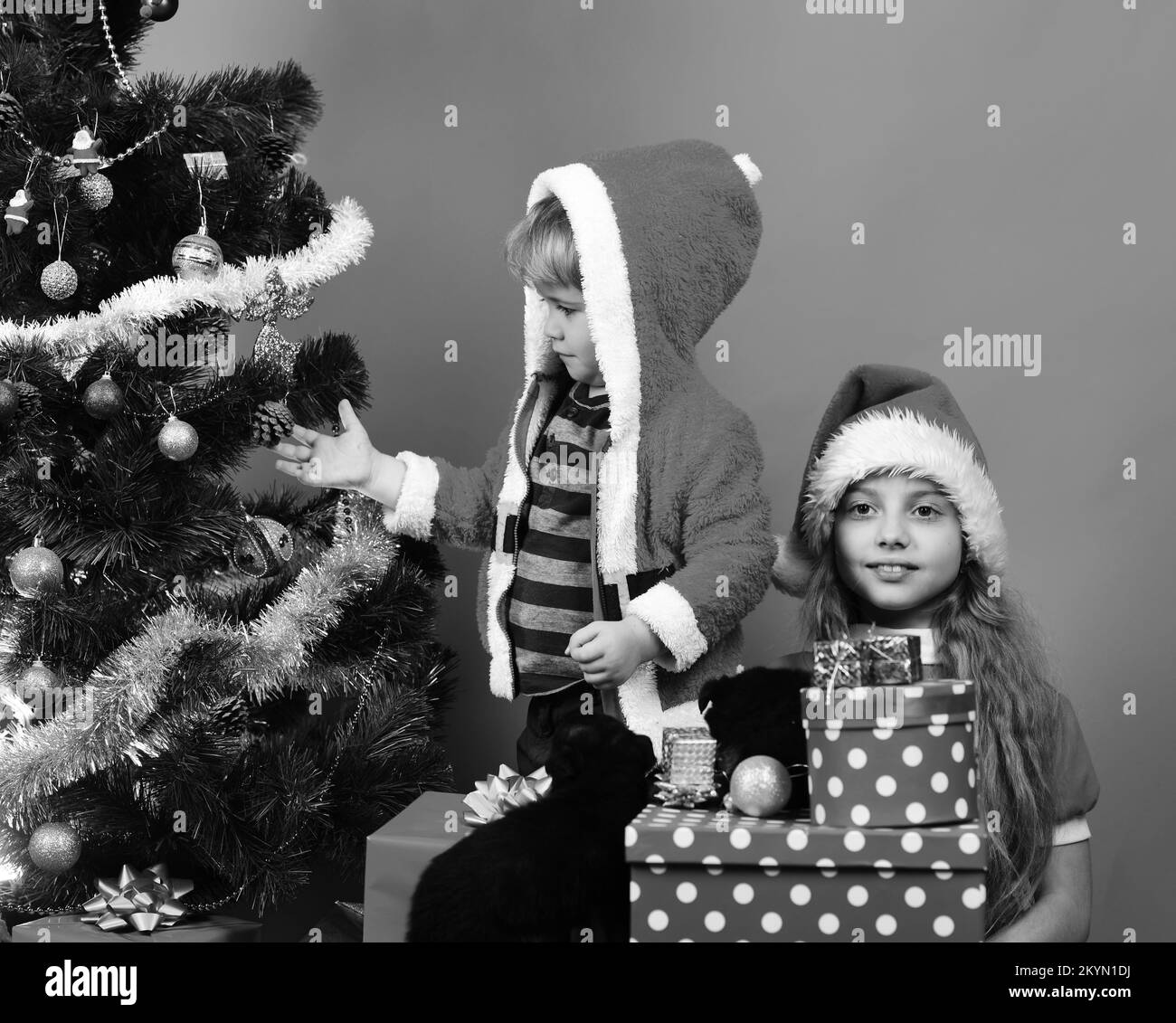 Kids with smiling faces unpack present boxes on red background Stock ...