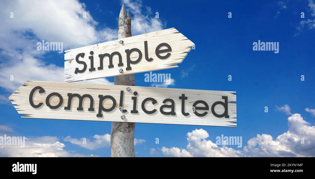 Simple or complicated - wooden signpost with two arrows Stock Photo - Alamy