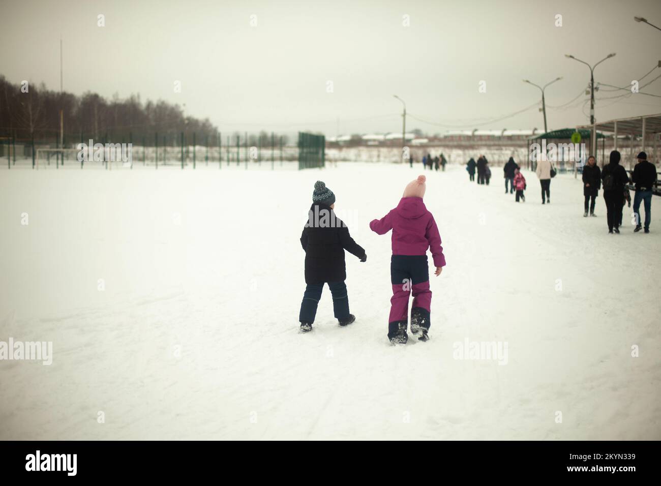 Children walk through snowy field. Children walk outside in winter ...