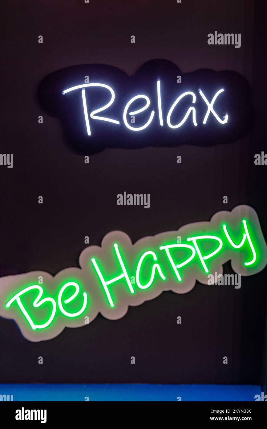 Neon Signs Relax and Be Happy at Black Wall Stock Photo - Alamy