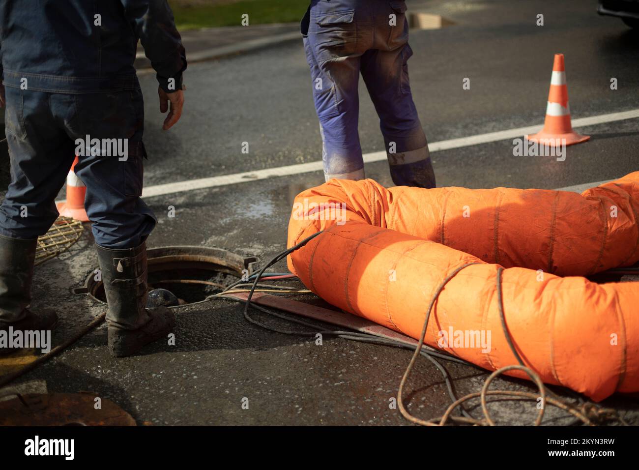 Workers and sewer hatch. Road repairs. Two workers opened hatch on road ...