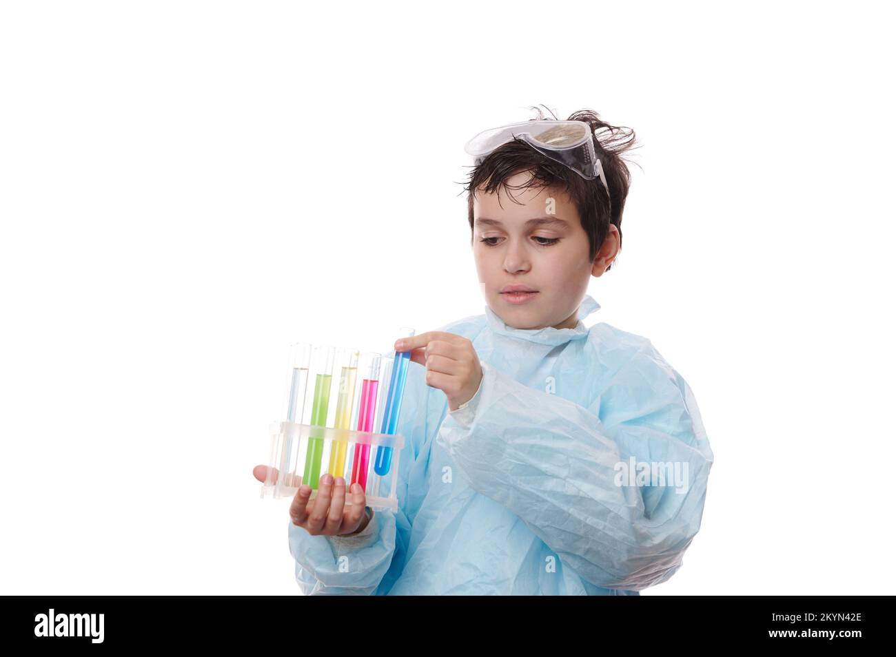 Close-up smart teenage boy, young pupil chemist in lab coat, conducts ...