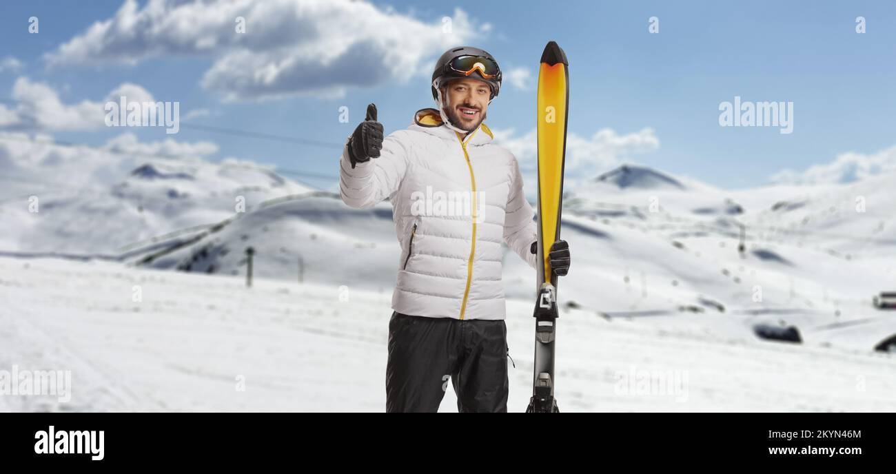 Happy male skier showing thumbs up on a mountain ski resort Stock Photo ...