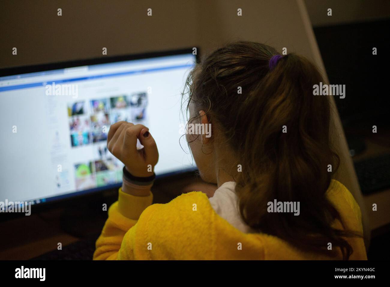 Girl looks at monitor. Girl searches on Internet. Student studies at ...