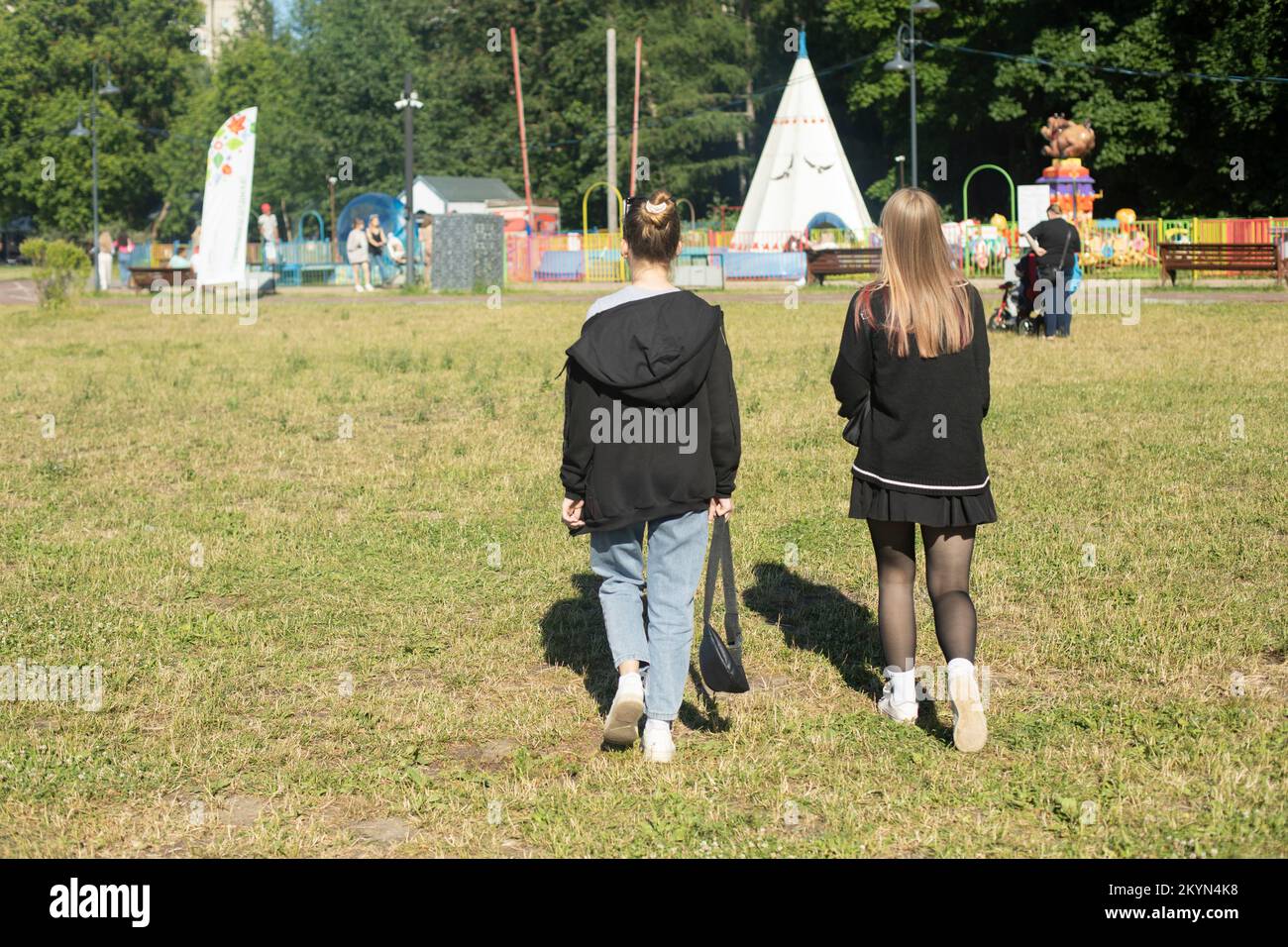 Girls walk in park in summer. Students at festival. Walking on green ...