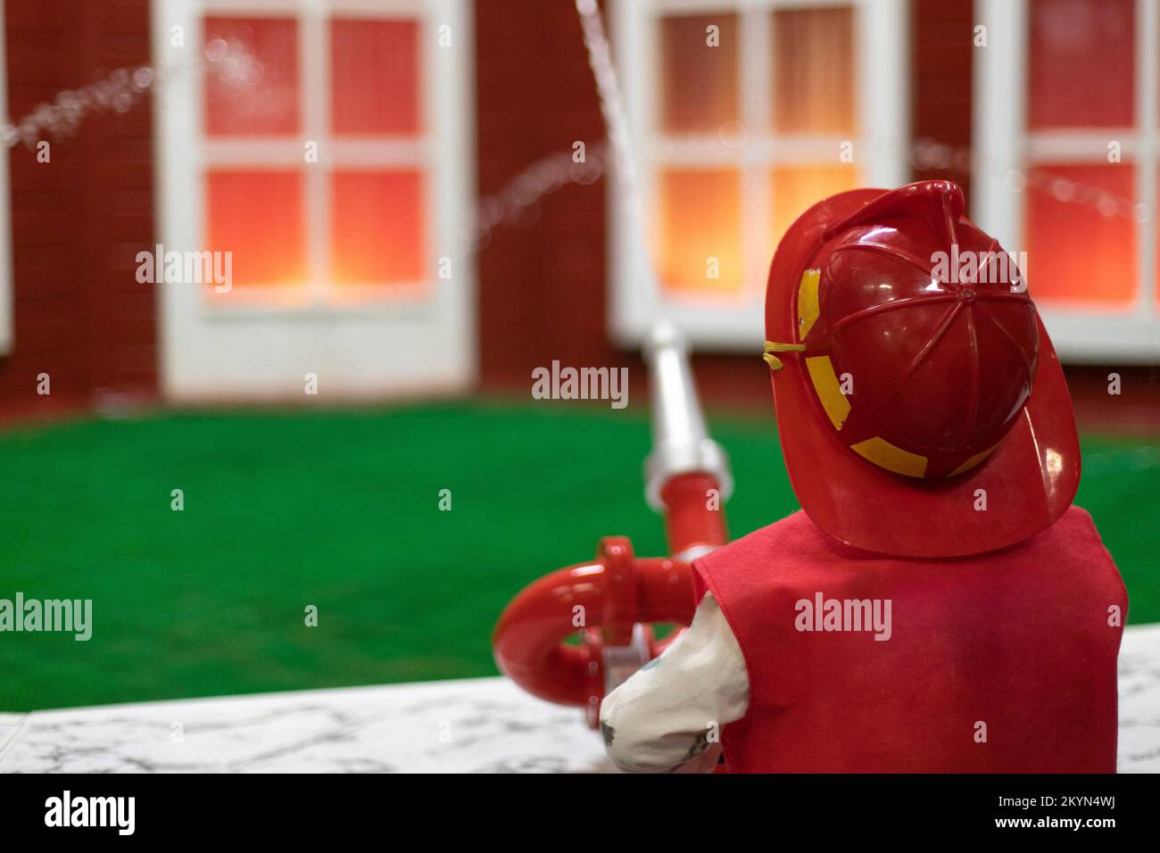 Little fireman. Baby puts out fire. Boy pours water on flames. Burning ...