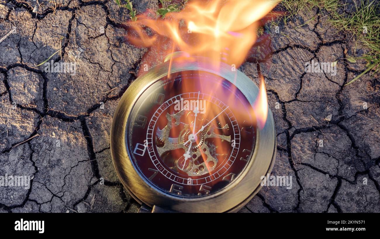 Burning pocket watch on dry cracked soil Stock Photo - Alamy