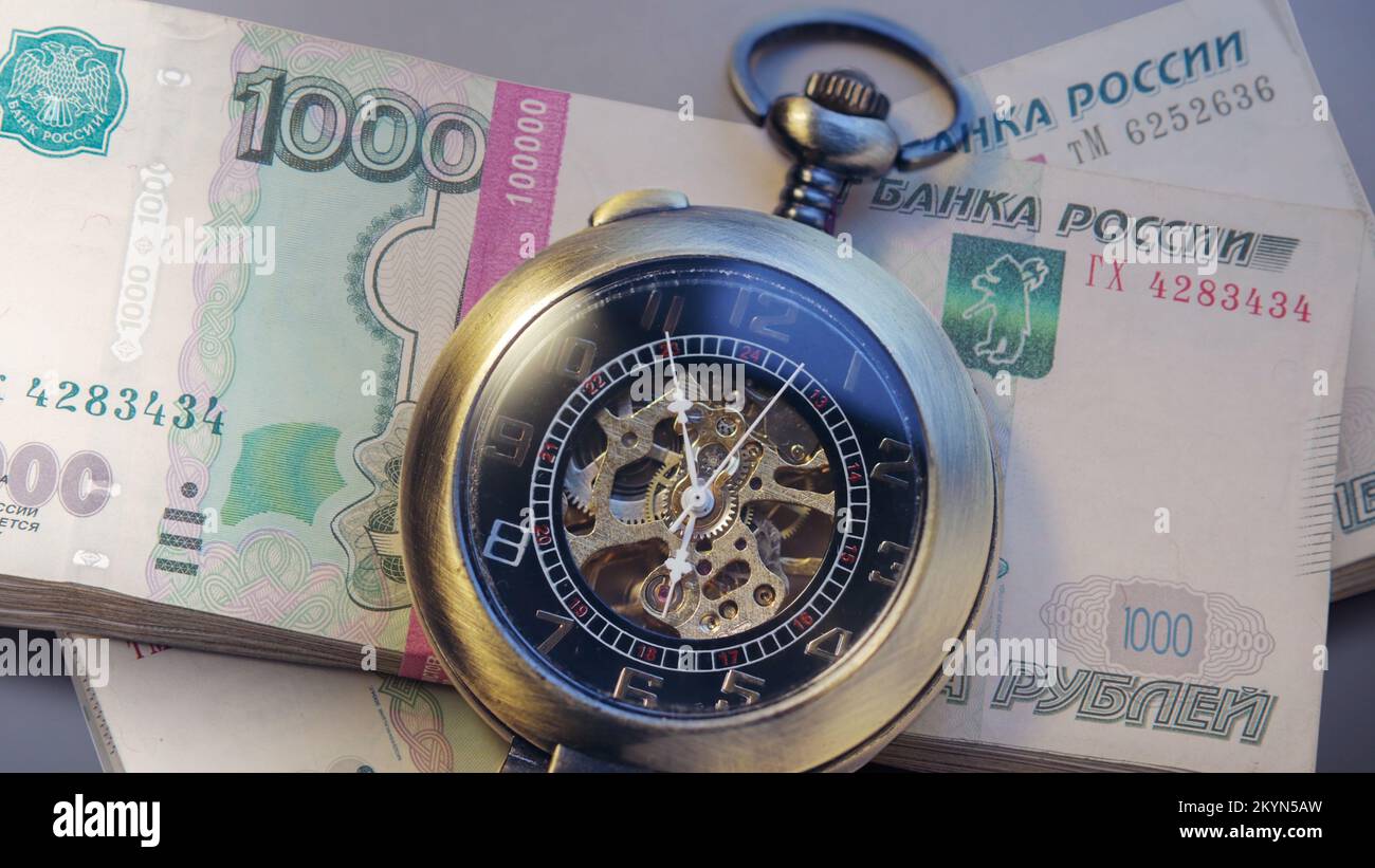 Pocket watch with pile of money in wrapper Stock Photo - Alamy