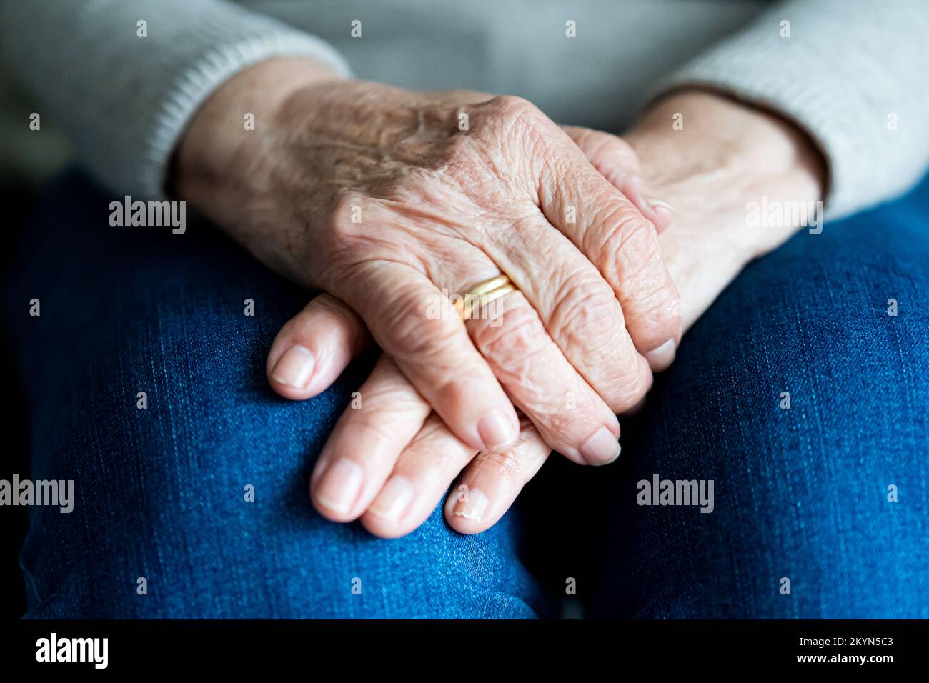 Hands of an elderly widow with her husband wedding ring next to hers ...
