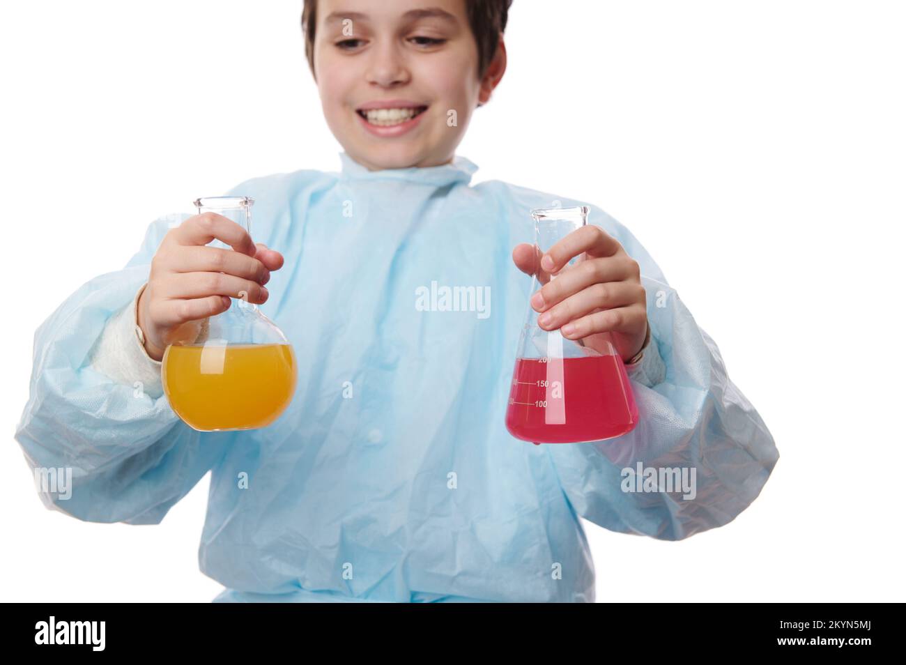 Focus on hands of smart nerd schoolboy in lab coat, holding glass ...