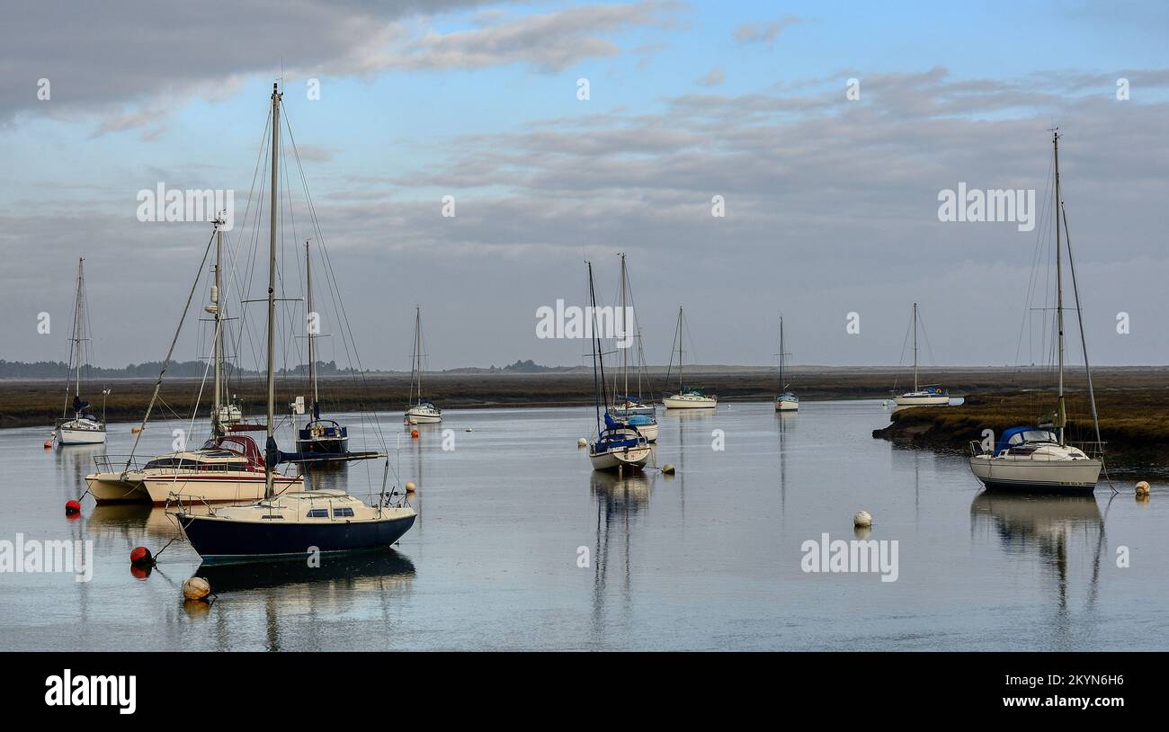 Boats reflected in the calm waters of the harbour at Wells-next-the-Sea ...