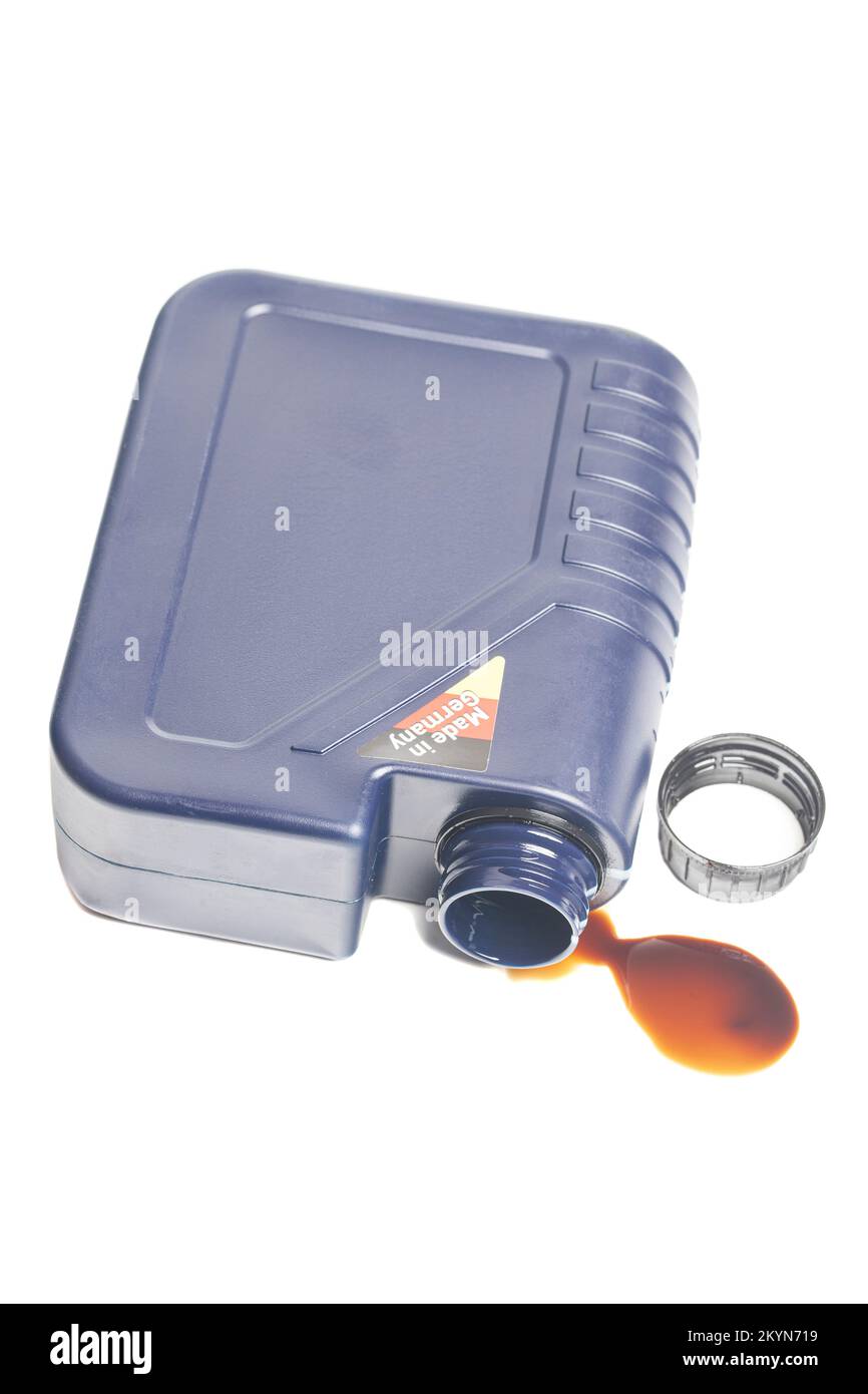 open engine oil bottle with a puddle of engine oil isolated on white ...