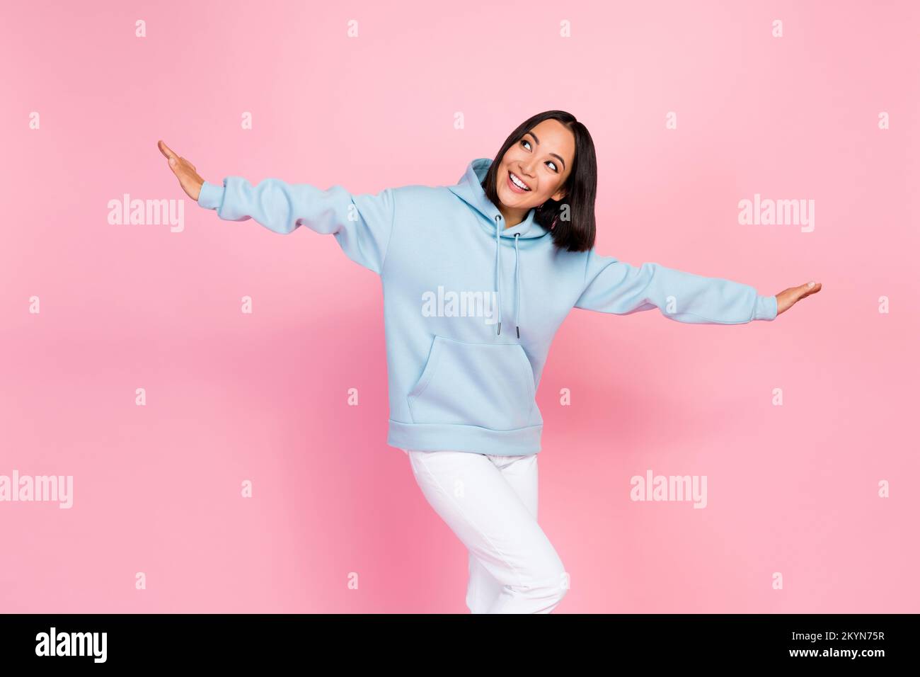 Photo portrait of cute young girl spread hands flying look empty space ...