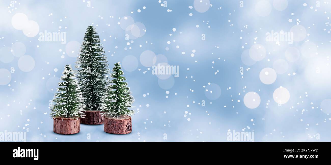 Mini Christmas trees on snow design background Stock Photo - Alamy