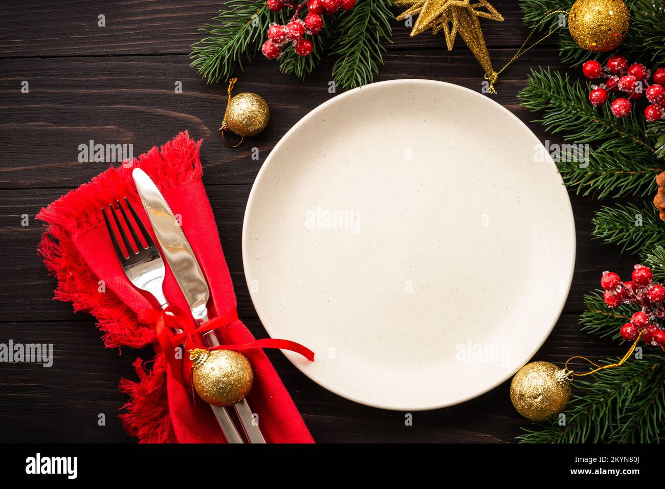Christmas table setting with plate, cutlery and christmas decorations ...
