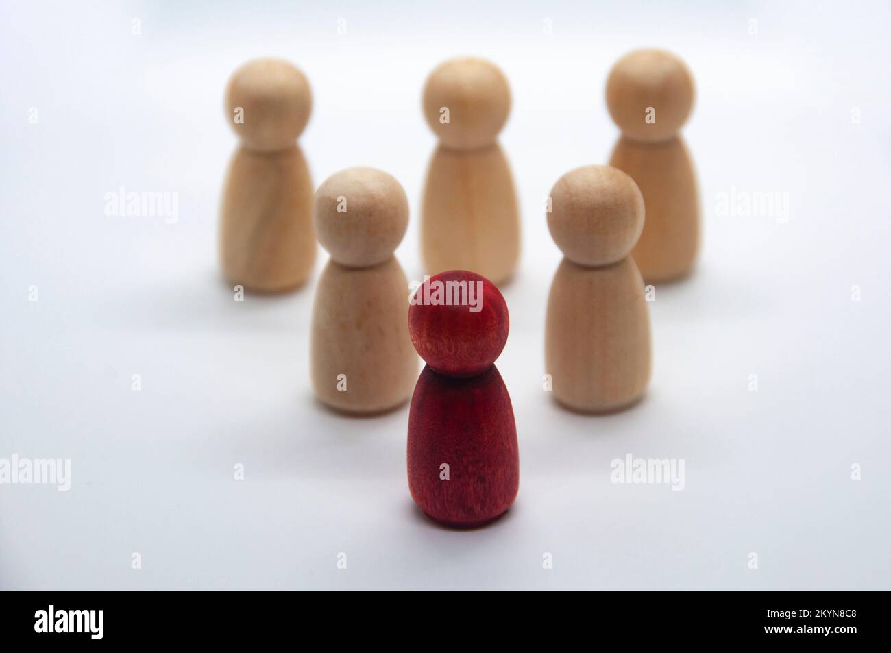 Red figure leading other wooden figure with white background ...