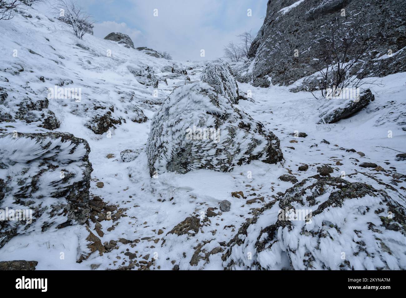 Trail between rocks with snow and ice to Mount Alenga near Southern ...