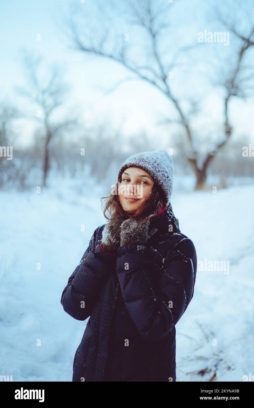 Young woman enjoying winter weather in the snow forest. Cold weather ...