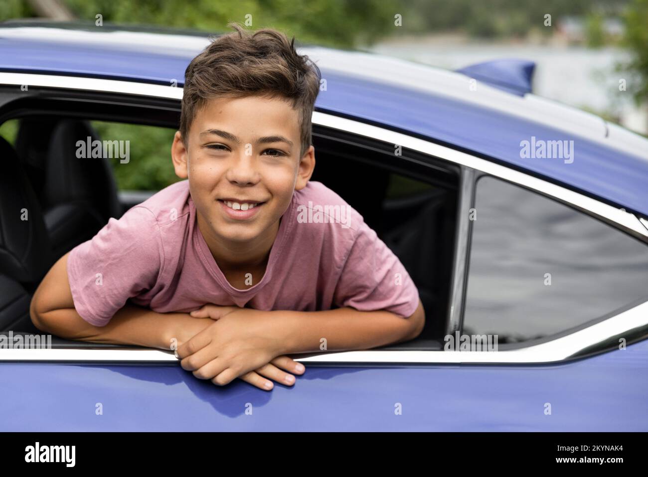 Portrait of excited boy leaning outside through car window Stock Photo ...